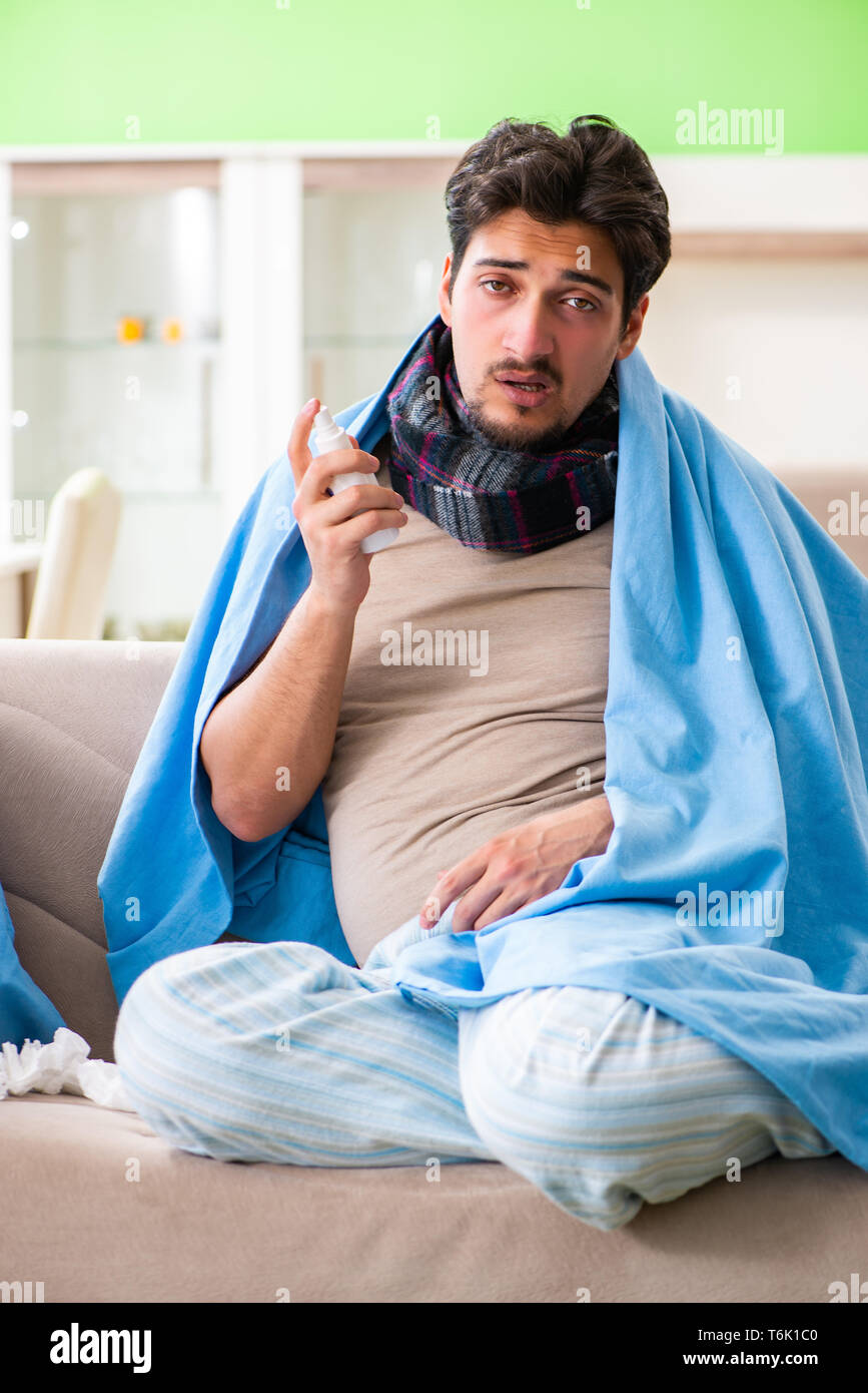 Sick young man suffering from flu at home Stock Photo - Alamy