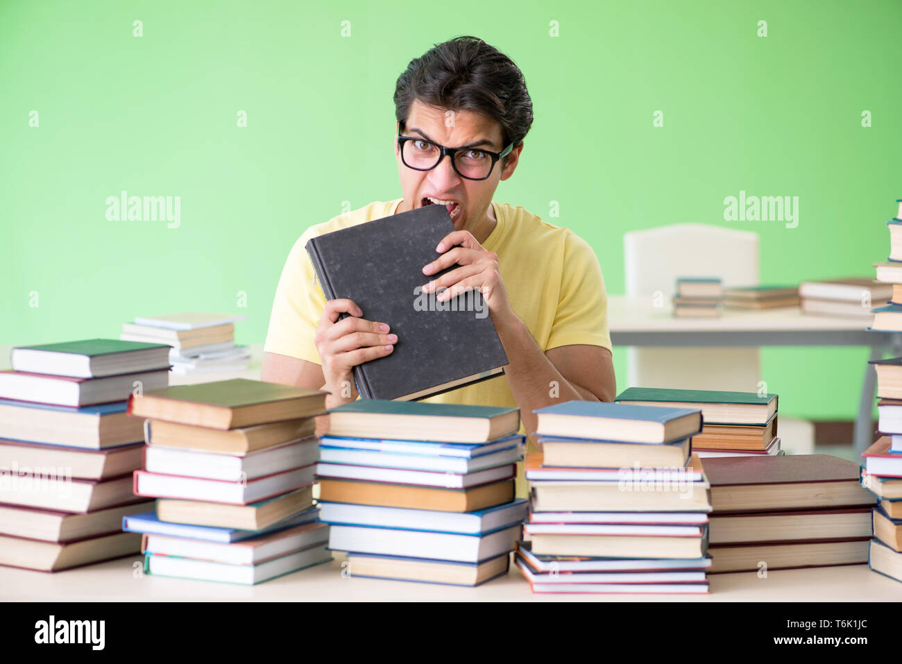 Student with too many books to read before exam Stock Photo - Alamy