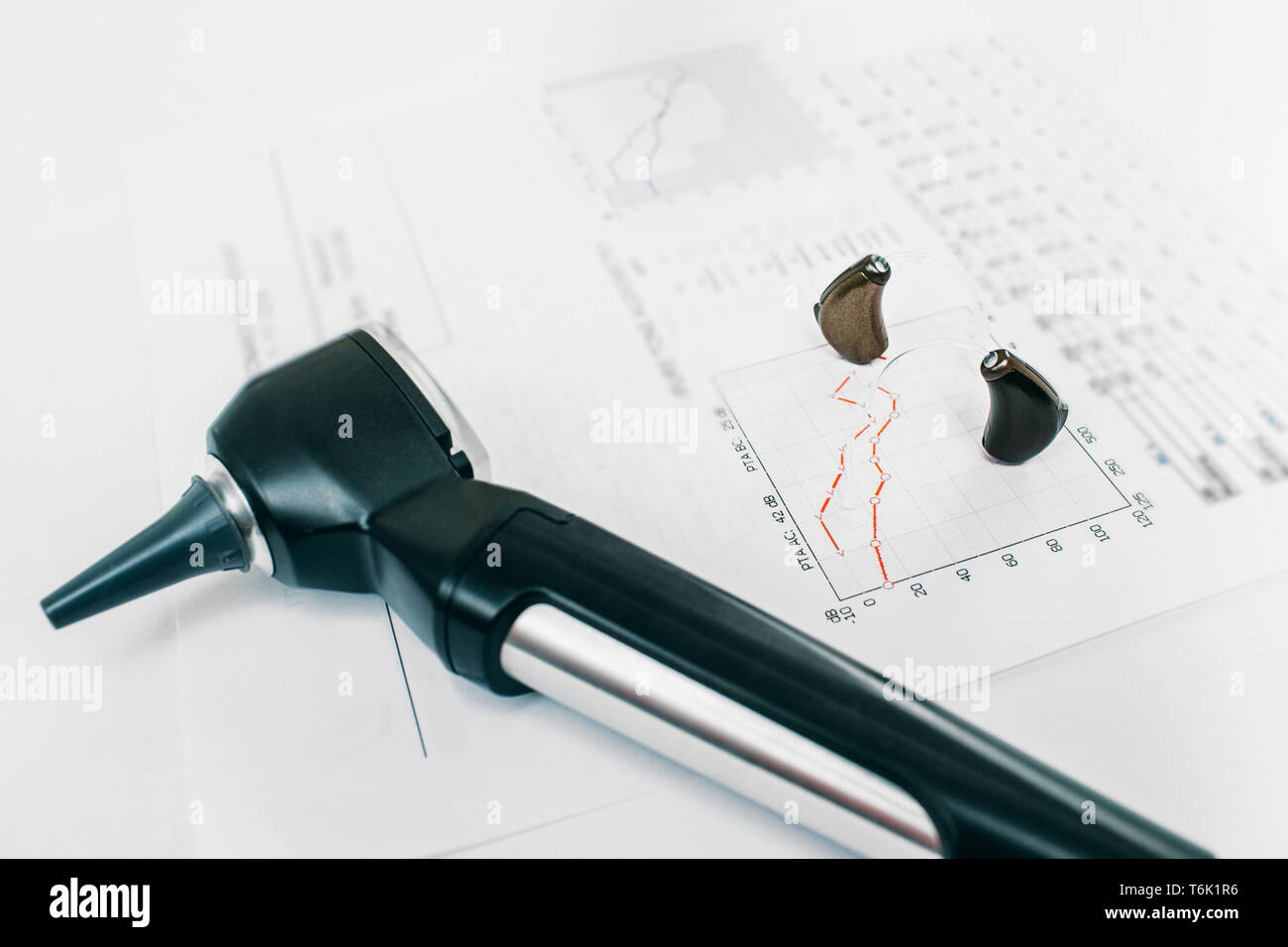 hearing exam concept. Otoscope with hearing aids on table with hearing ...