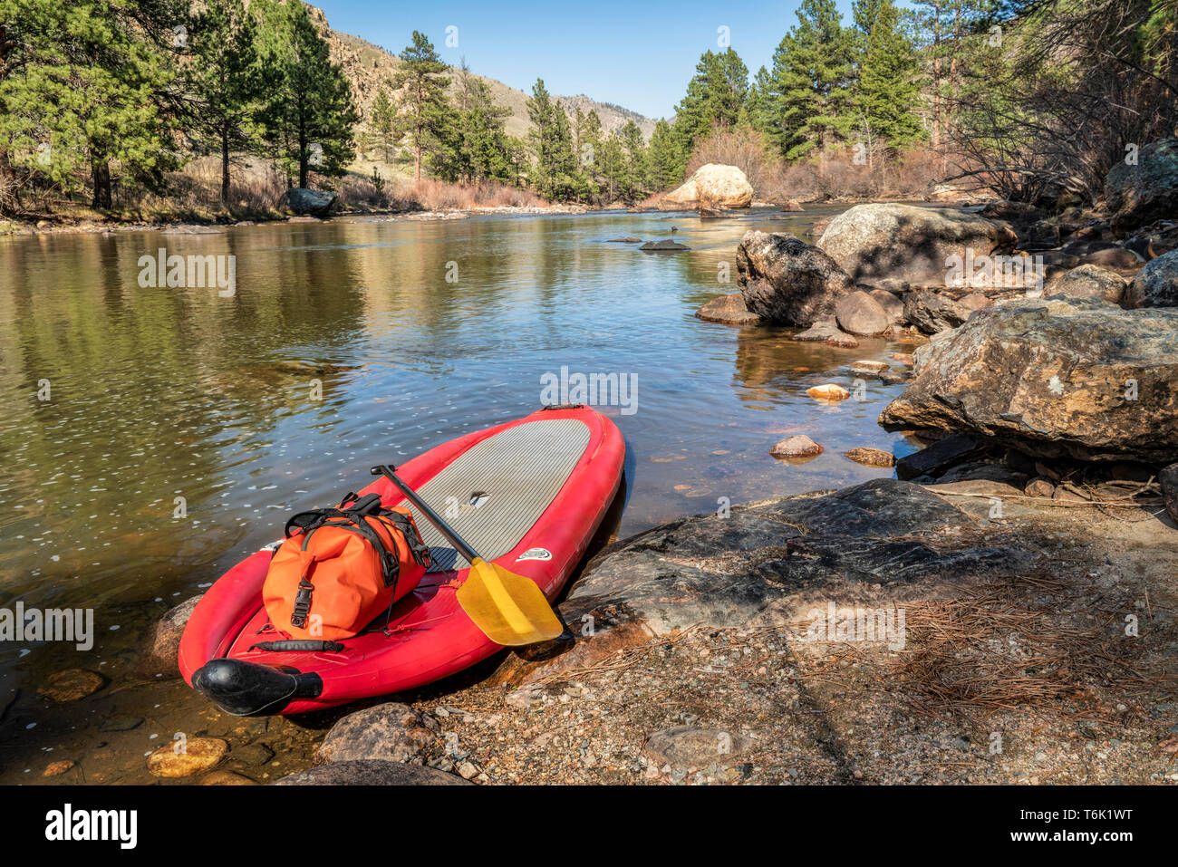 inflatable whitewater stand up paddleboard on a shore of mountain river ...