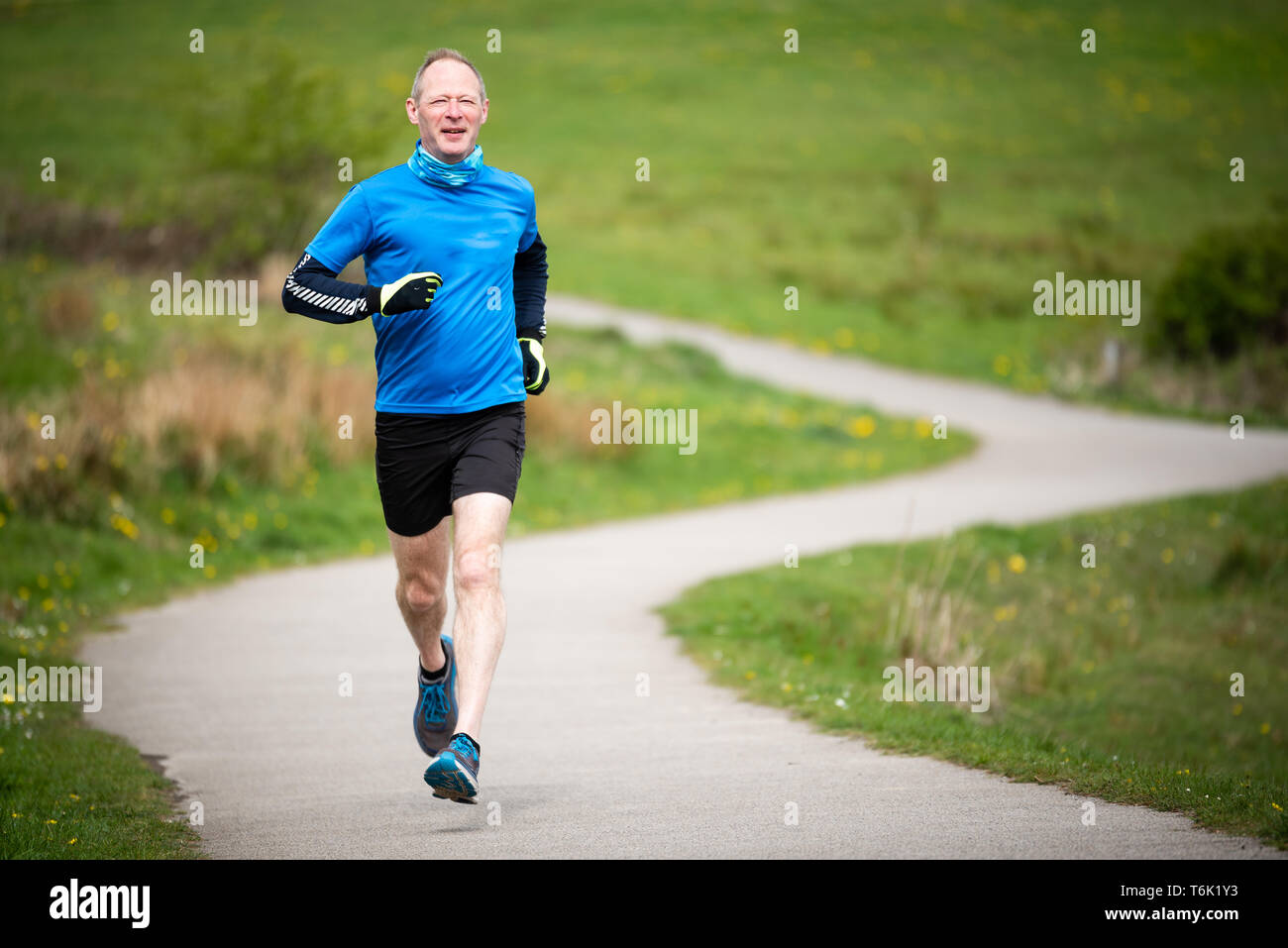 Senior man in 50s exercising and keeping fit by running in a park Stock ...