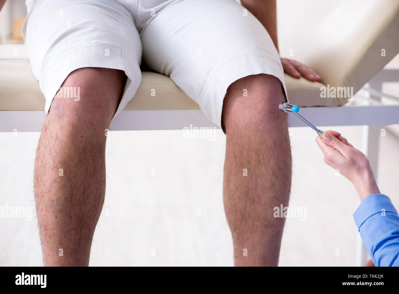 Doctor checking nerve reflexes with hammer Stock Photo - Alamy