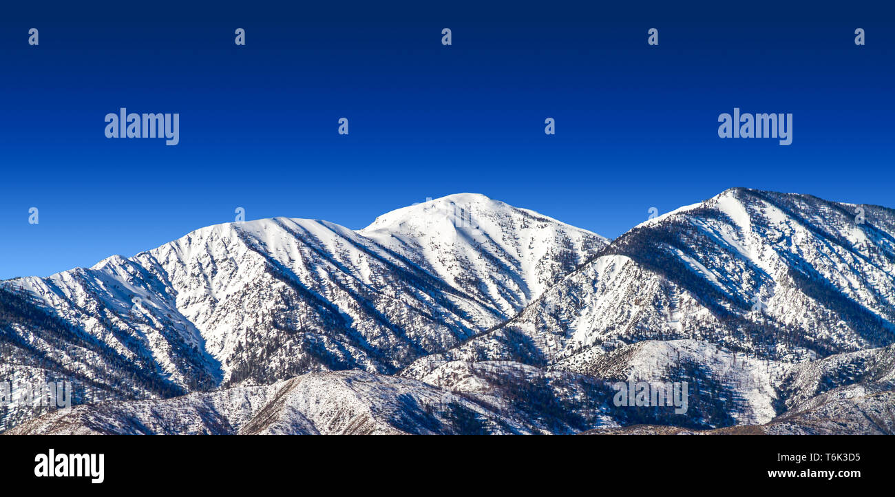 Snowy mountain range with clear blue sky in the San Gabriel Mountains ...