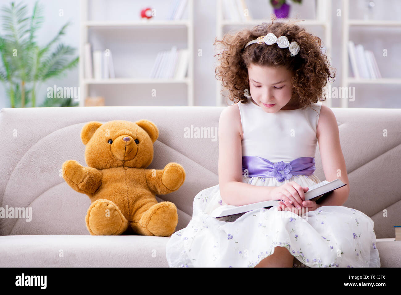 Little pretty girl reading books at home Stock Photo - Alamy