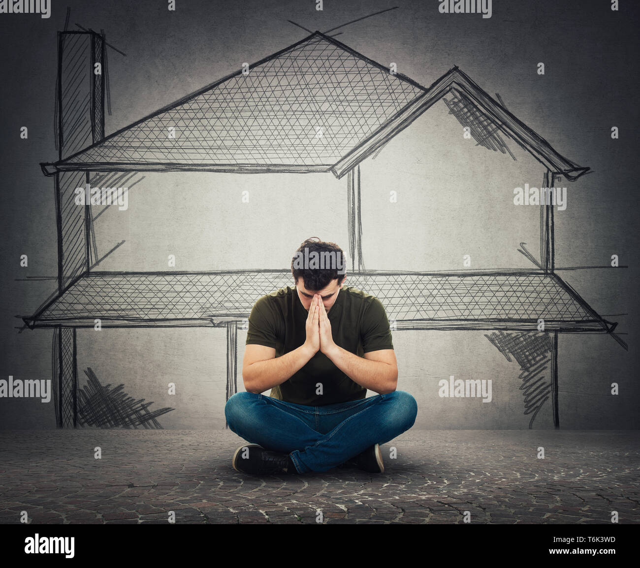 Stressed man sitting on the street with hands folded together praying ...