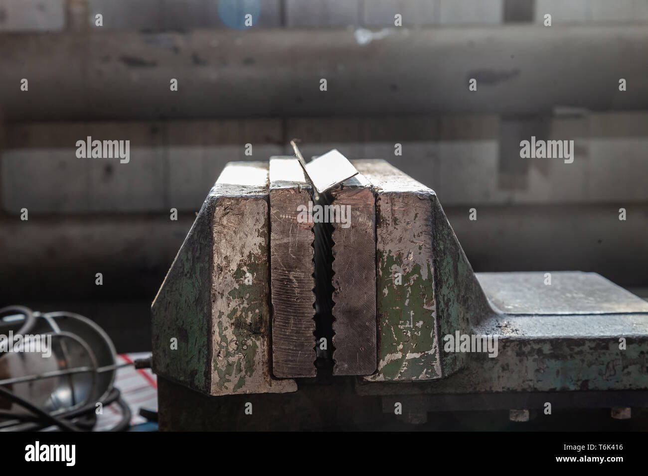 Large and powerful green vise with overwhelmed paint on a blue ...