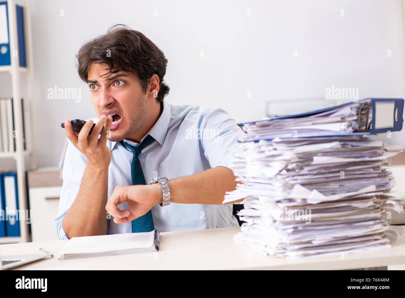 Overloaded busy employee with too much work and paperwork Stock Photo ...