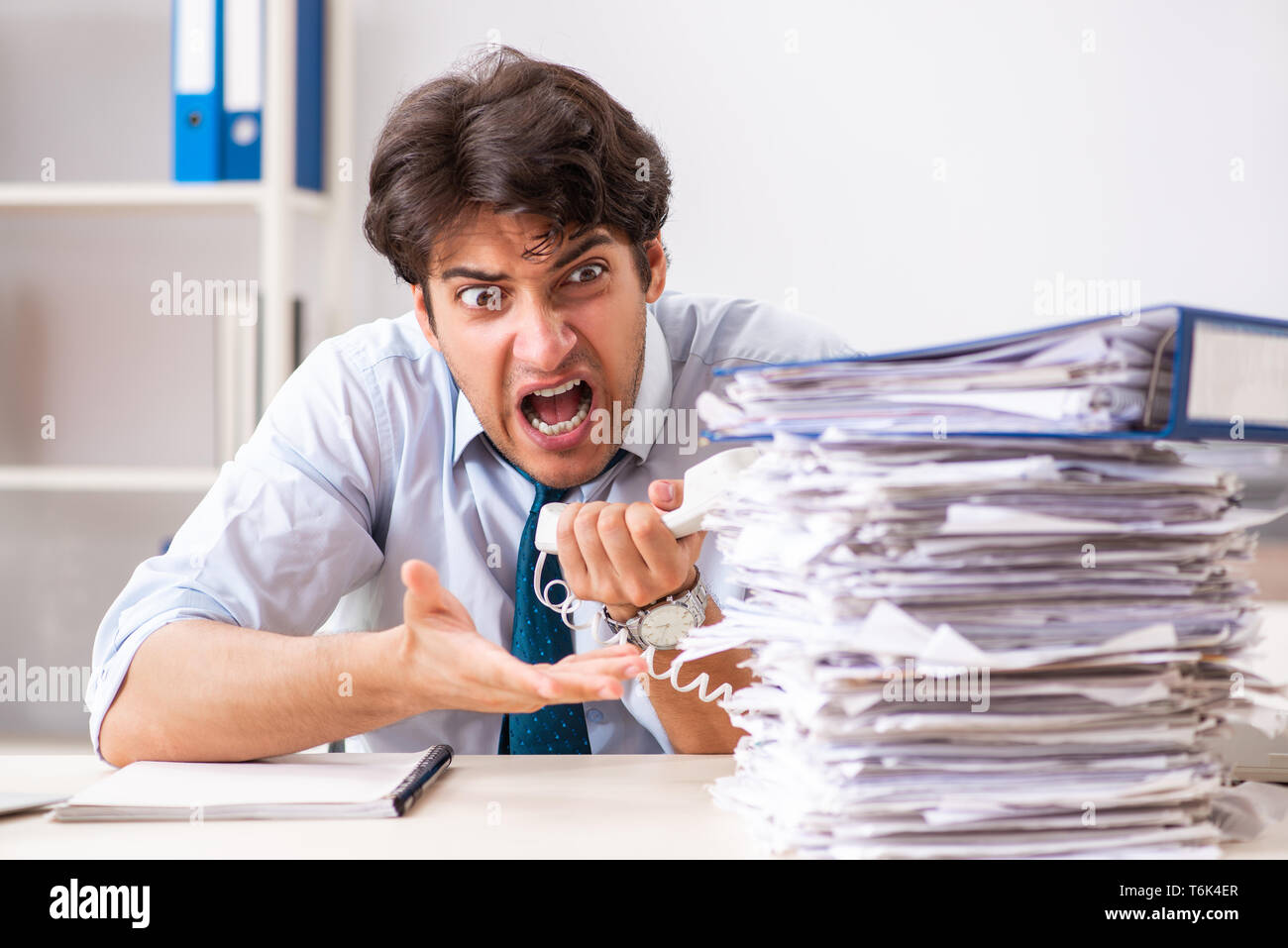 Overloaded busy employee with too much work and paperwork Stock Photo ...