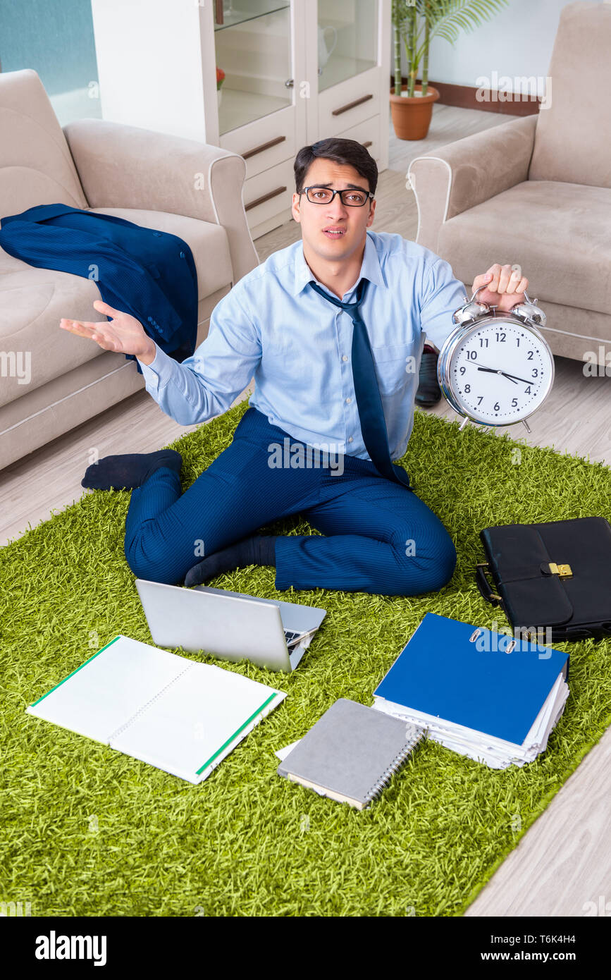 Businessman taking work home and working overtime Stock Photo - Alamy
