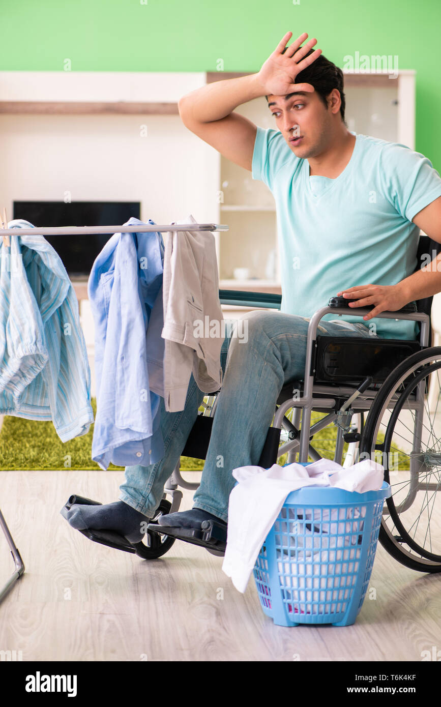 Disabled man on wheelchair doing laundry Stock Photo - Alamy