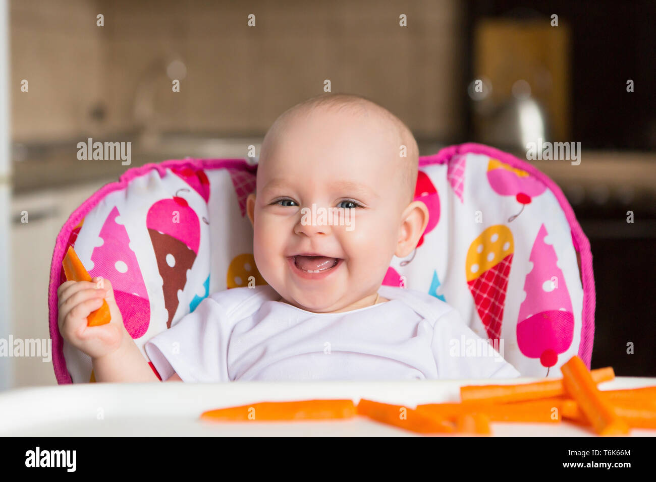 baby in a child seat eating vegetables.baby in the baby chair eating ...