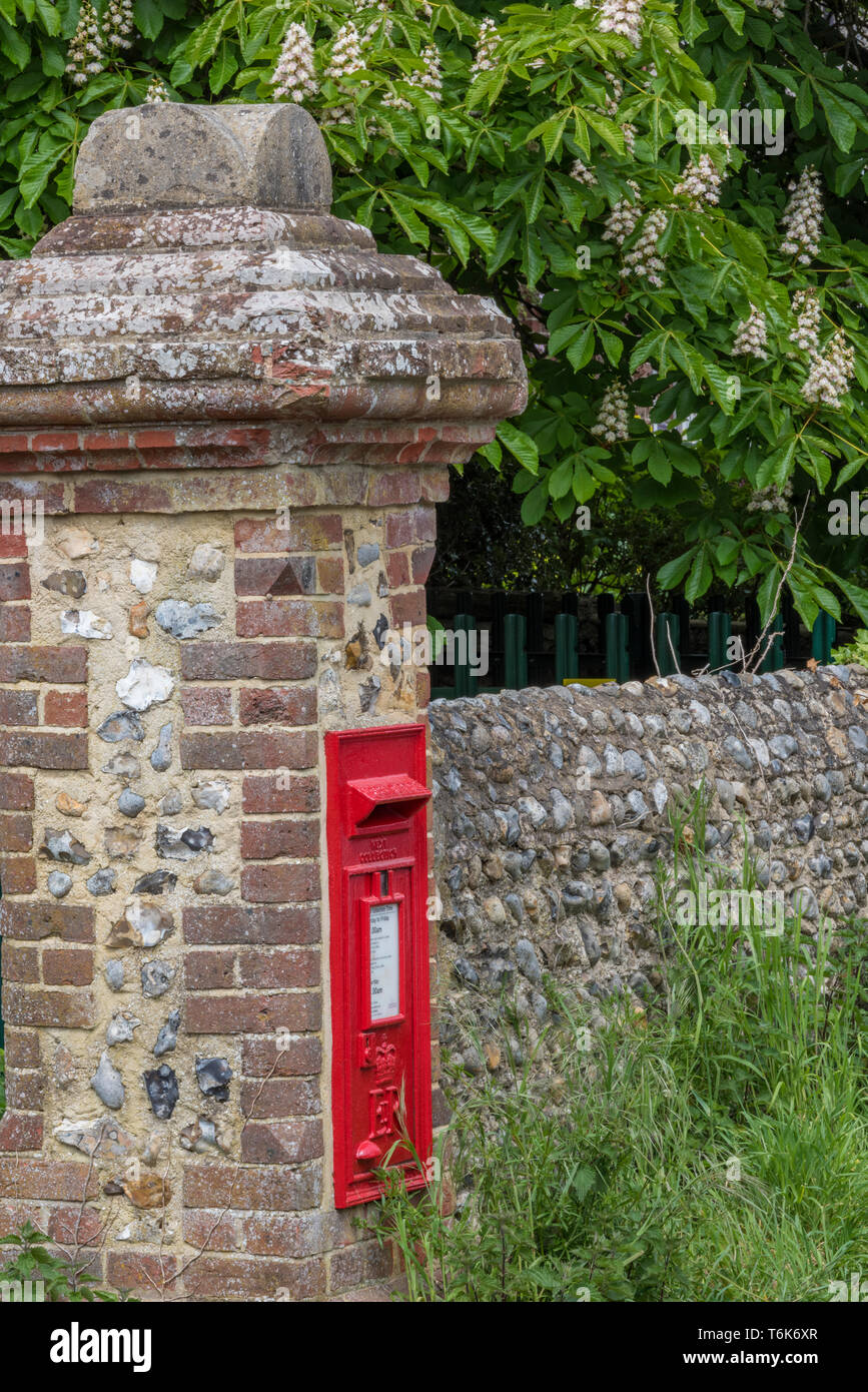 a traditional british postal posting box set into an old red brick wall ...