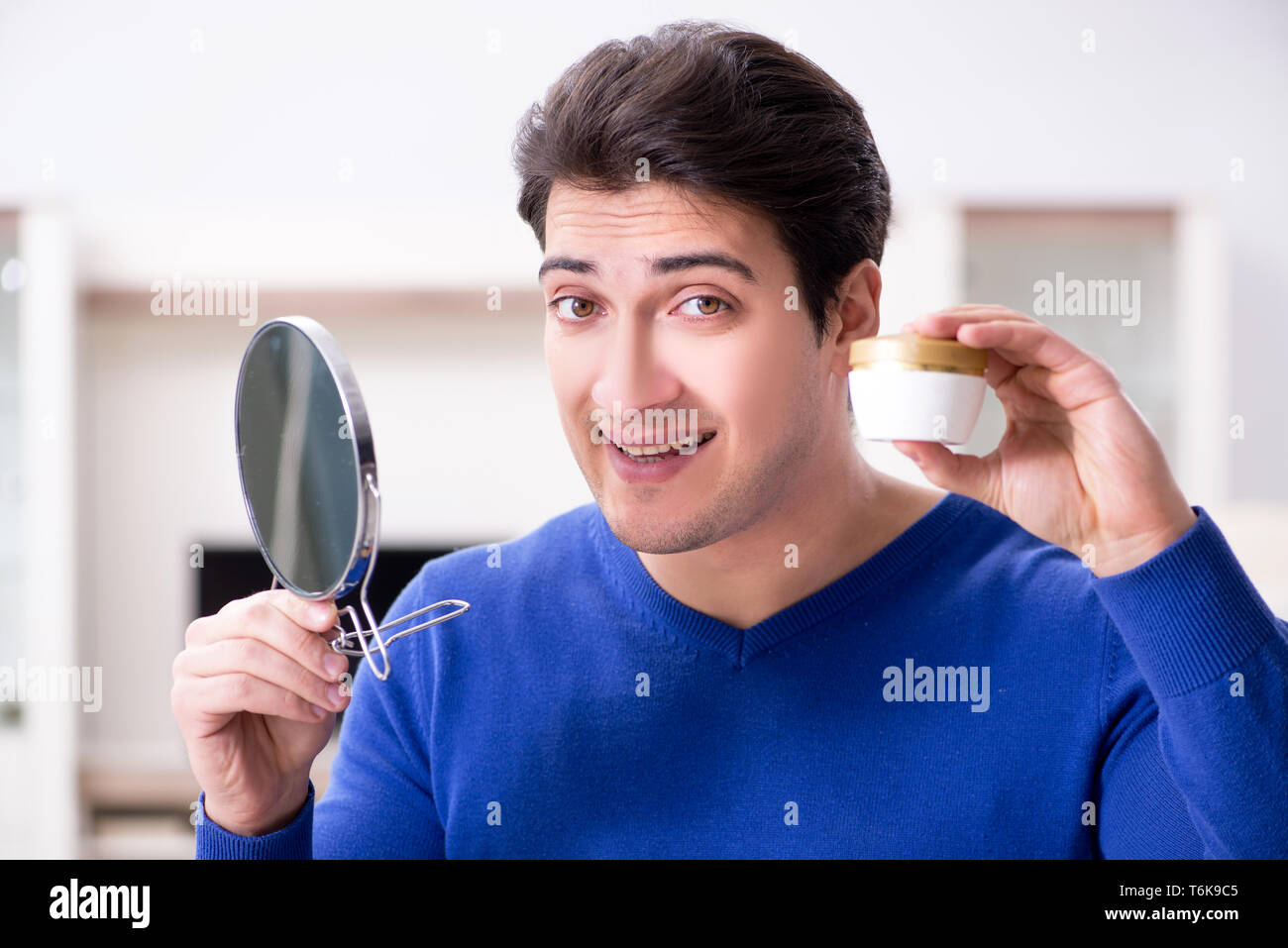 The young handsome man taking care of face skin Stock Photo - Alamy