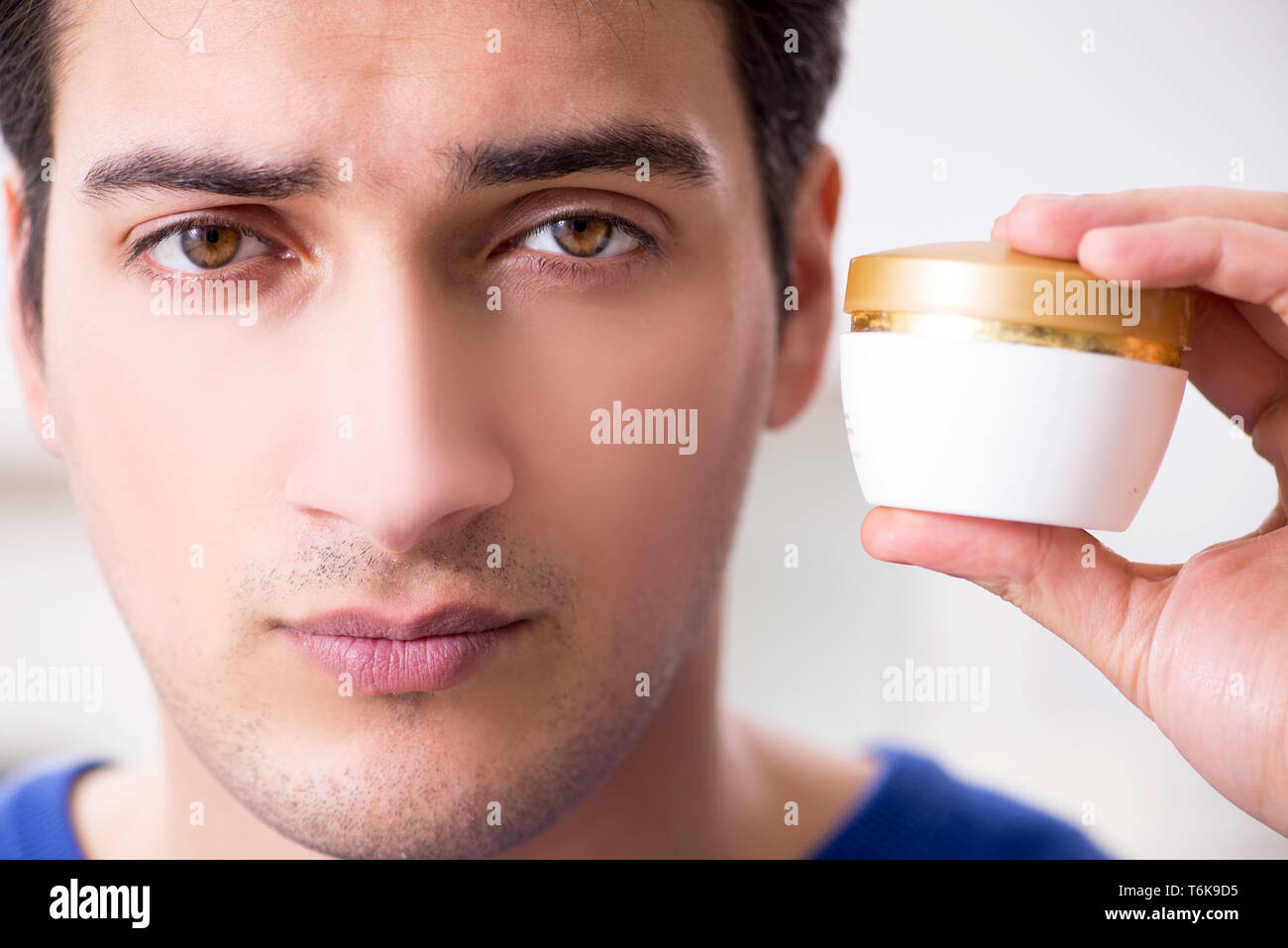 The young handsome man taking care of face skin Stock Photo - Alamy