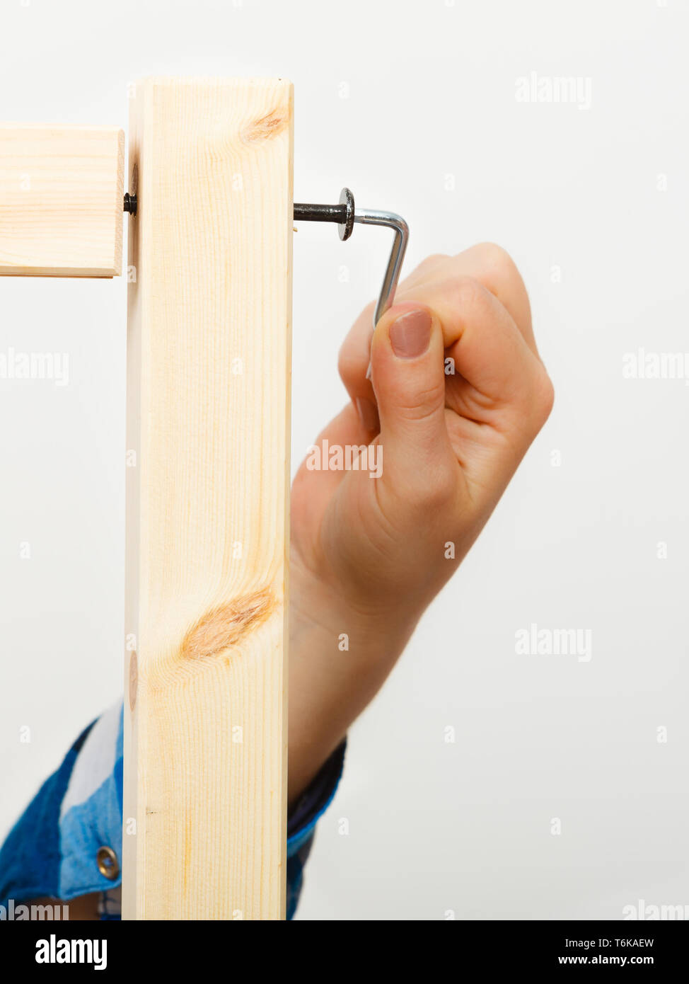 Human hand assembling wooden furniture using hex key. DIY enthusiast ...