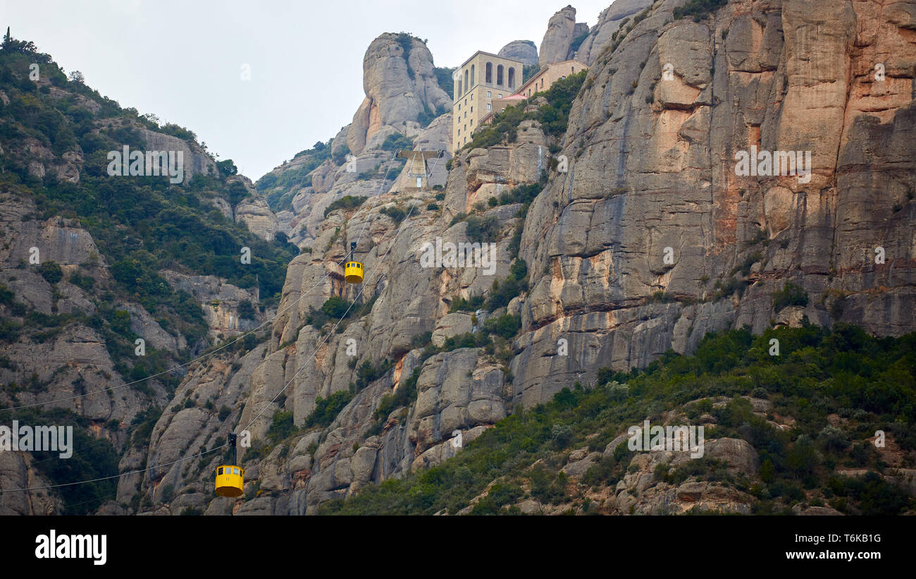 Yellow cable car in the Aeri de Montserrat rise to de Montserrat Abbey ...