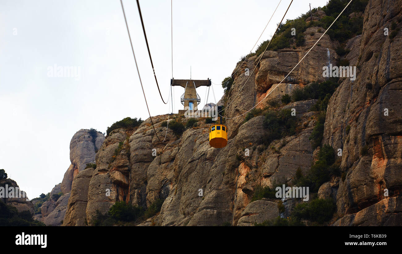 Yellow cable car in the Aeri de Montserrat rise to de Montserrat Abbey ...