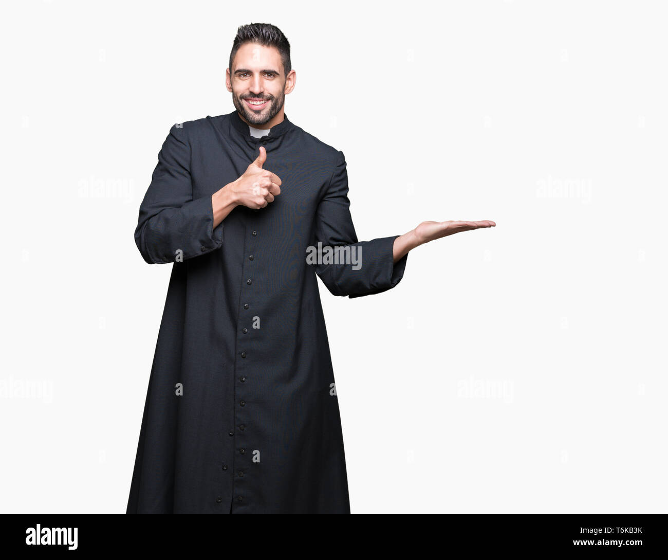 Young Christian priest over isolated background Showing palm hand and ...