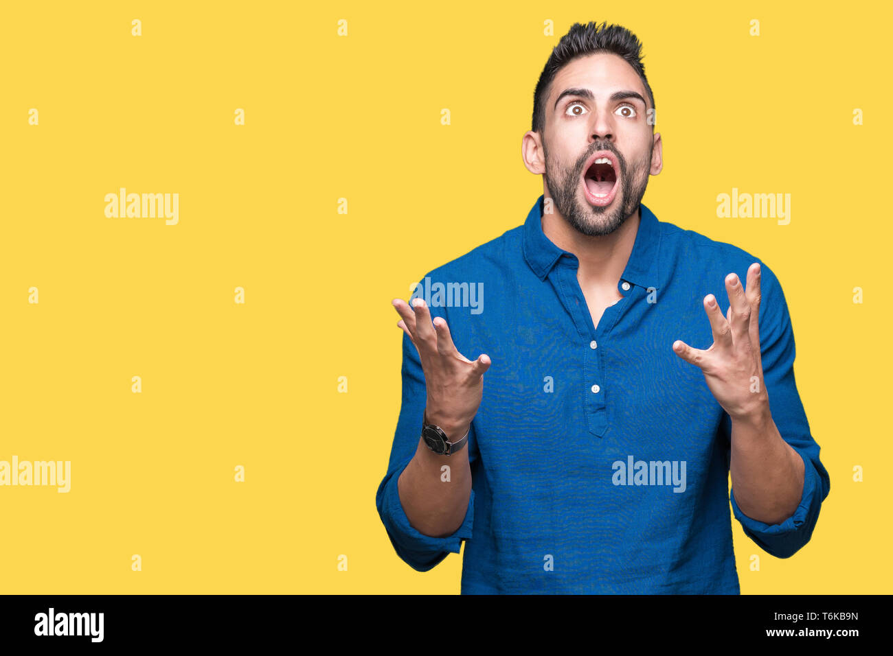 Young handsome man over isolated background crazy and mad shouting and ...