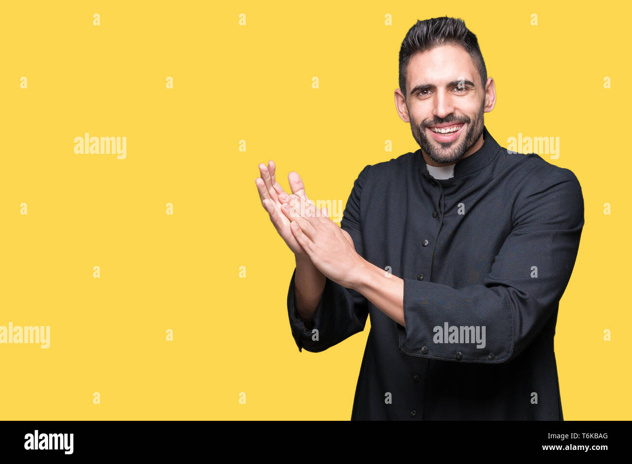 Young Christian priest over isolated background Clapping and applauding ...