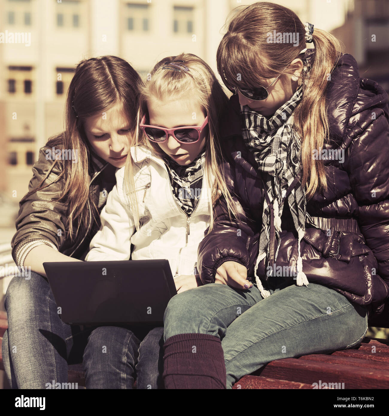 Group of teenage school girls using laptop on the bench Stock Photo - Alamy