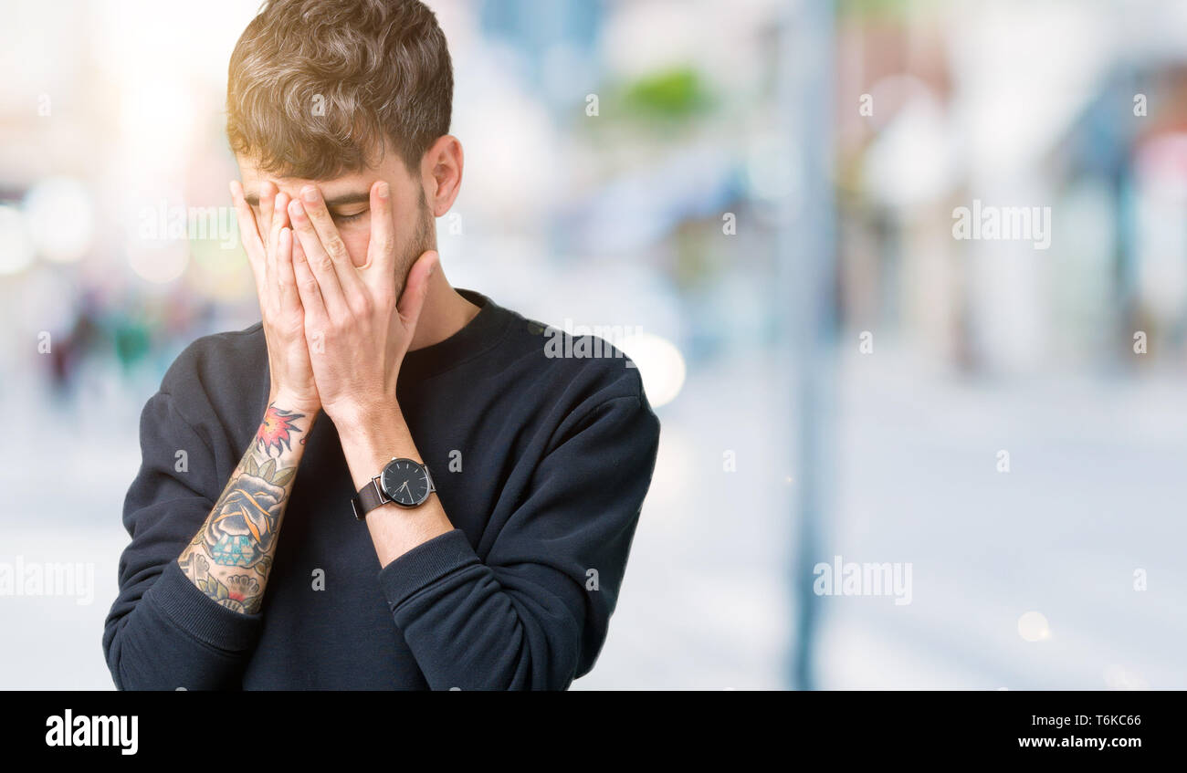 Young handsome man over isolated background with sad expression ...