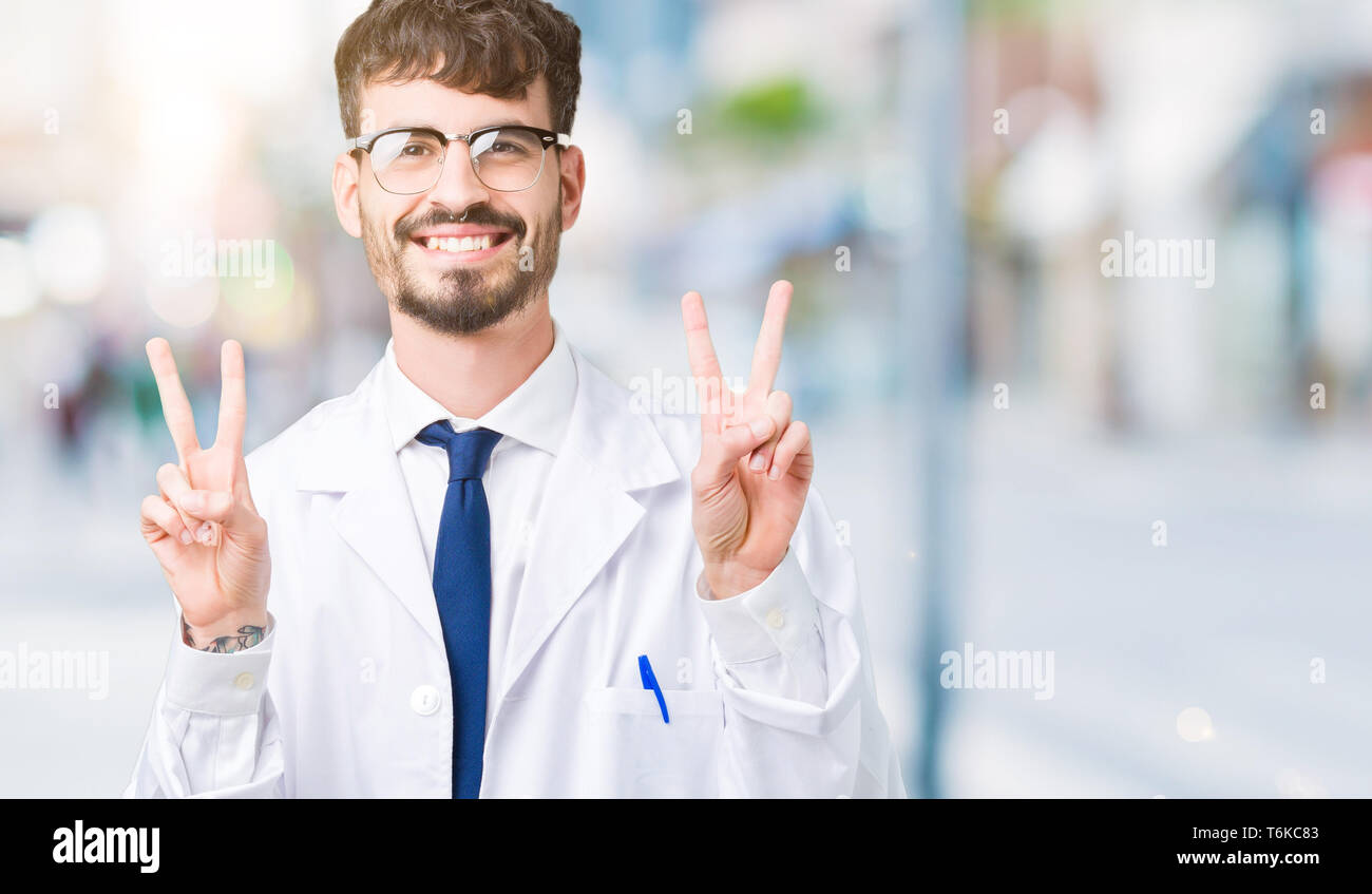 Young professional scientist man wearing white coat over isolated ...