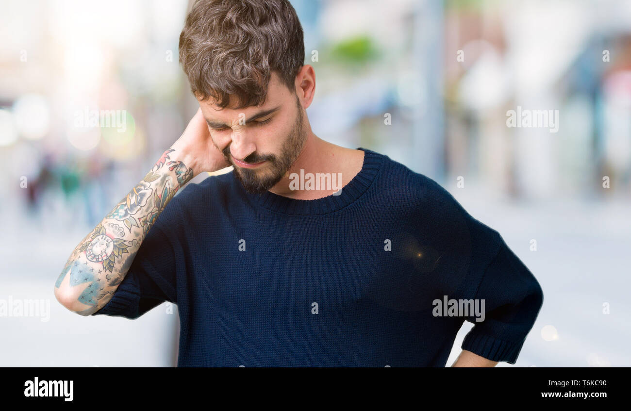 Young handsome man over isolated background Suffering of neck ache ...