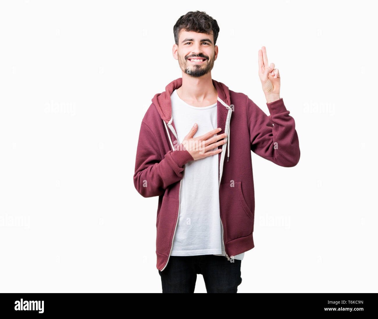 Young handsome man over isolated background Swearing with hand on chest ...
