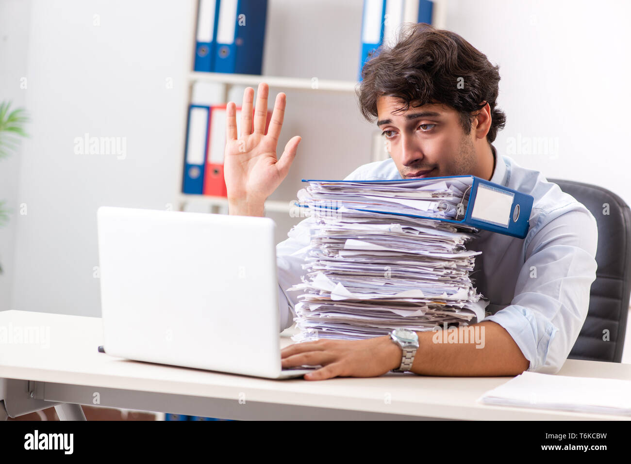 Overloaded busy employee with too much work and paperwork Stock Photo ...