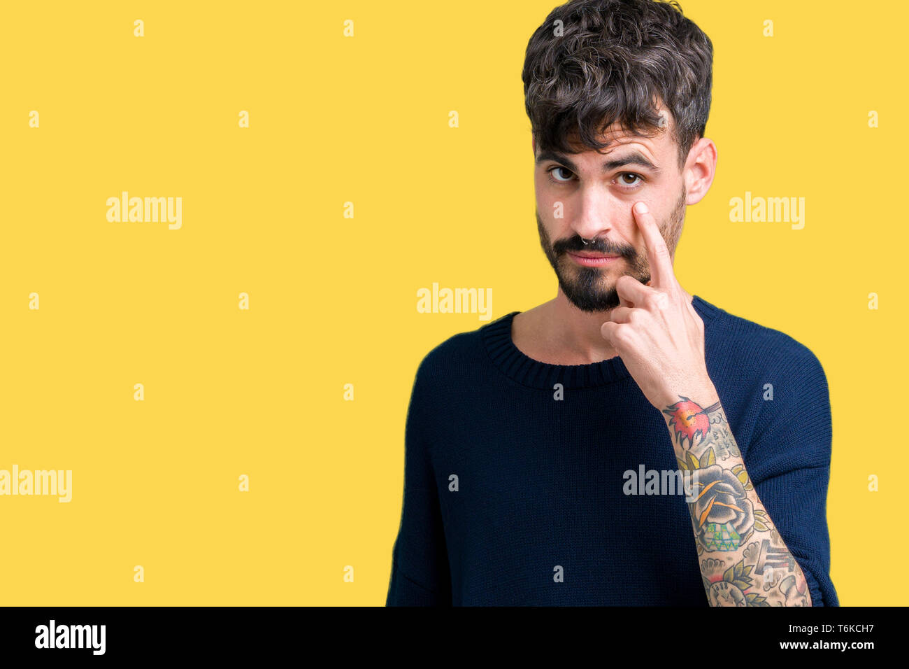Young handsome man over isolated background Pointing to the eye ...