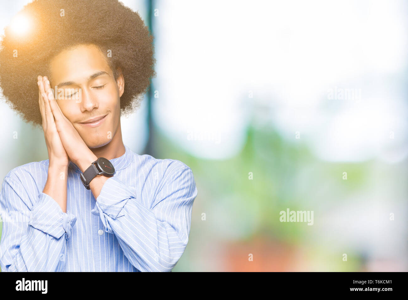 Young african american man with afro hair sleeping tired dreaming and ...