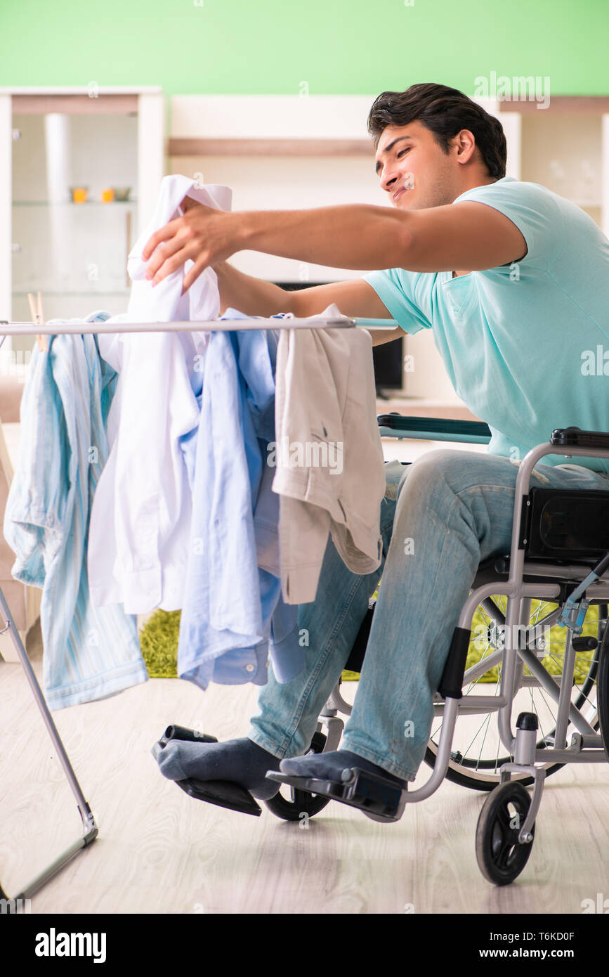 Disabled man on wheelchair doing laundry Stock Photo - Alamy