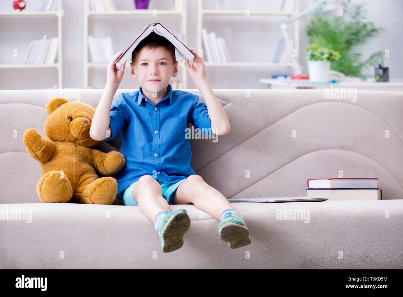 Small boy reading books at home Stock Photo - Alamy
