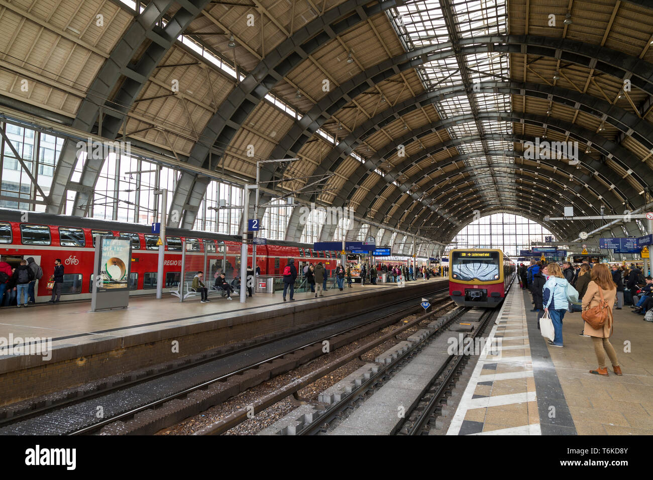 A lot of people waiting on the platform and S-Bahn train approaching ...