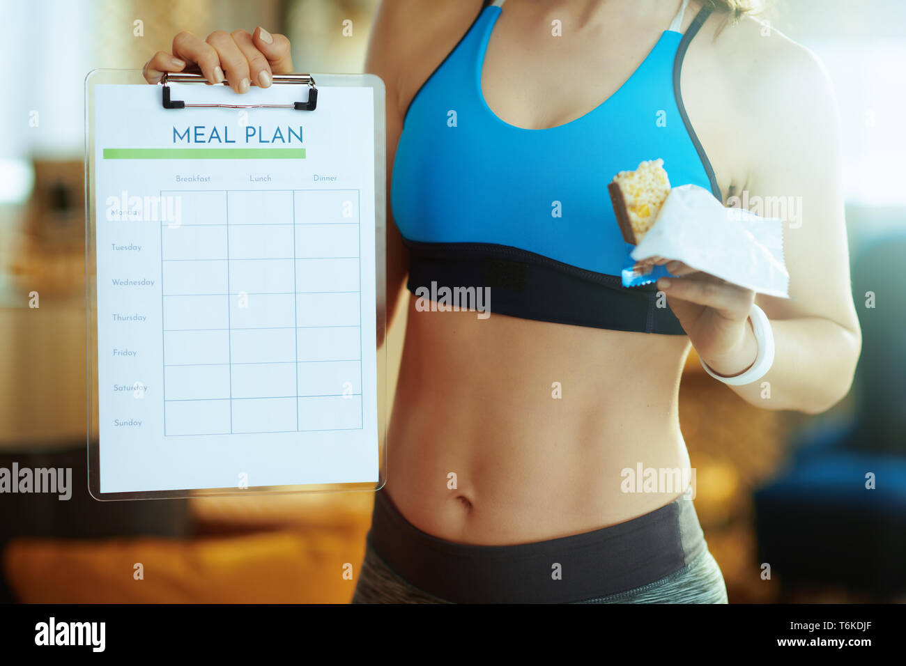 Closeup on fit sports woman in fitness clothes with fitness energy bar ...