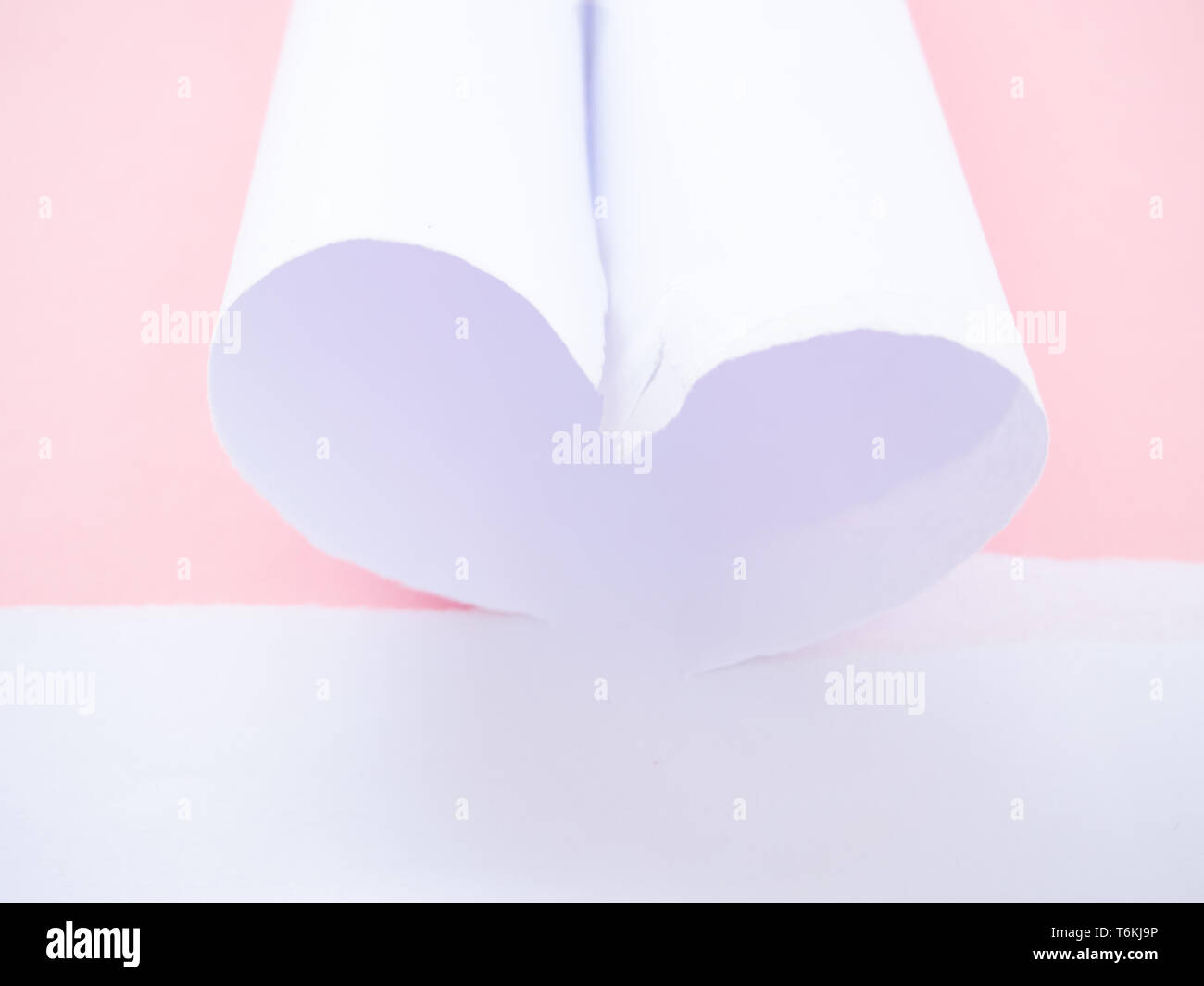 A torn white paper heart-shaped isolated in pastel pink Stock Photo - Alamy