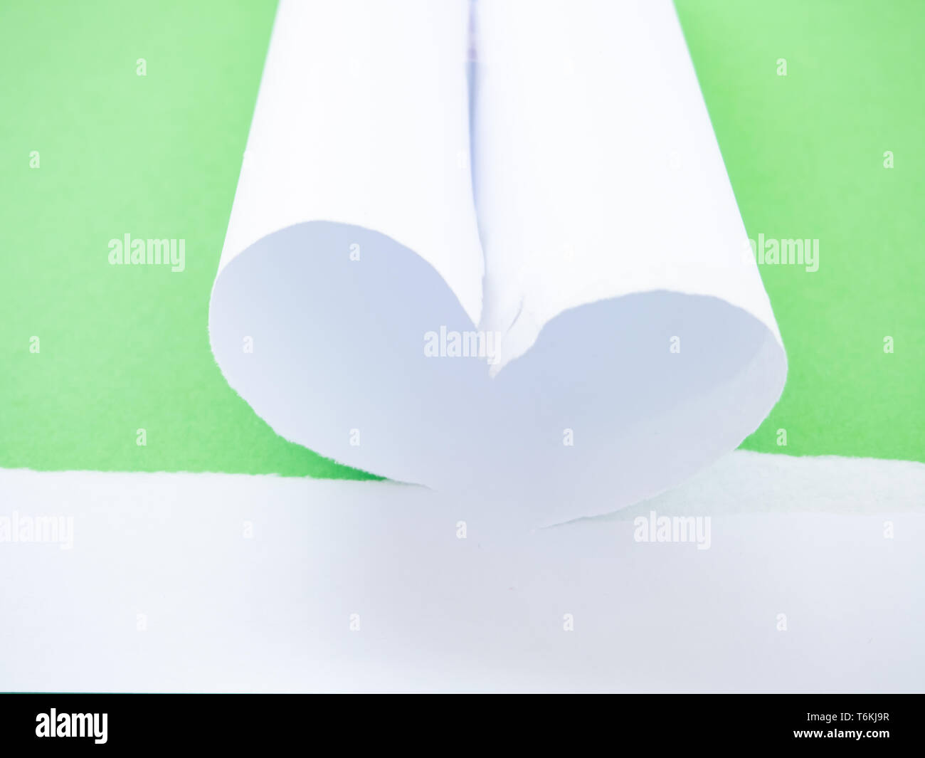 A torn white paper heart-shaped isolated in green Stock Photo - Alamy