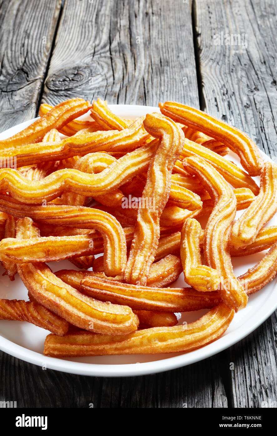 churros - traditional spanish and mexican dessert on a white platter on ...
