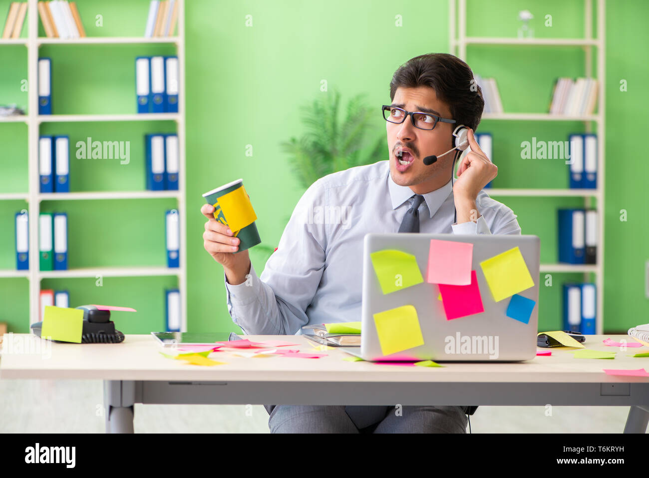 Young help desk operator working in office with many conflicting Stock ...