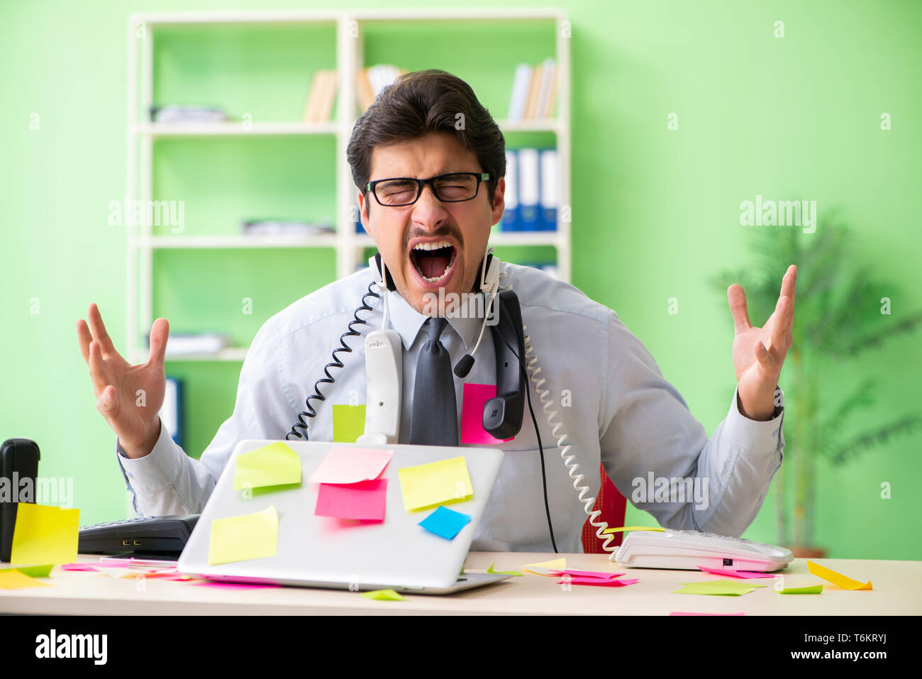 Young help desk operator working in office with many conflicting Stock ...
