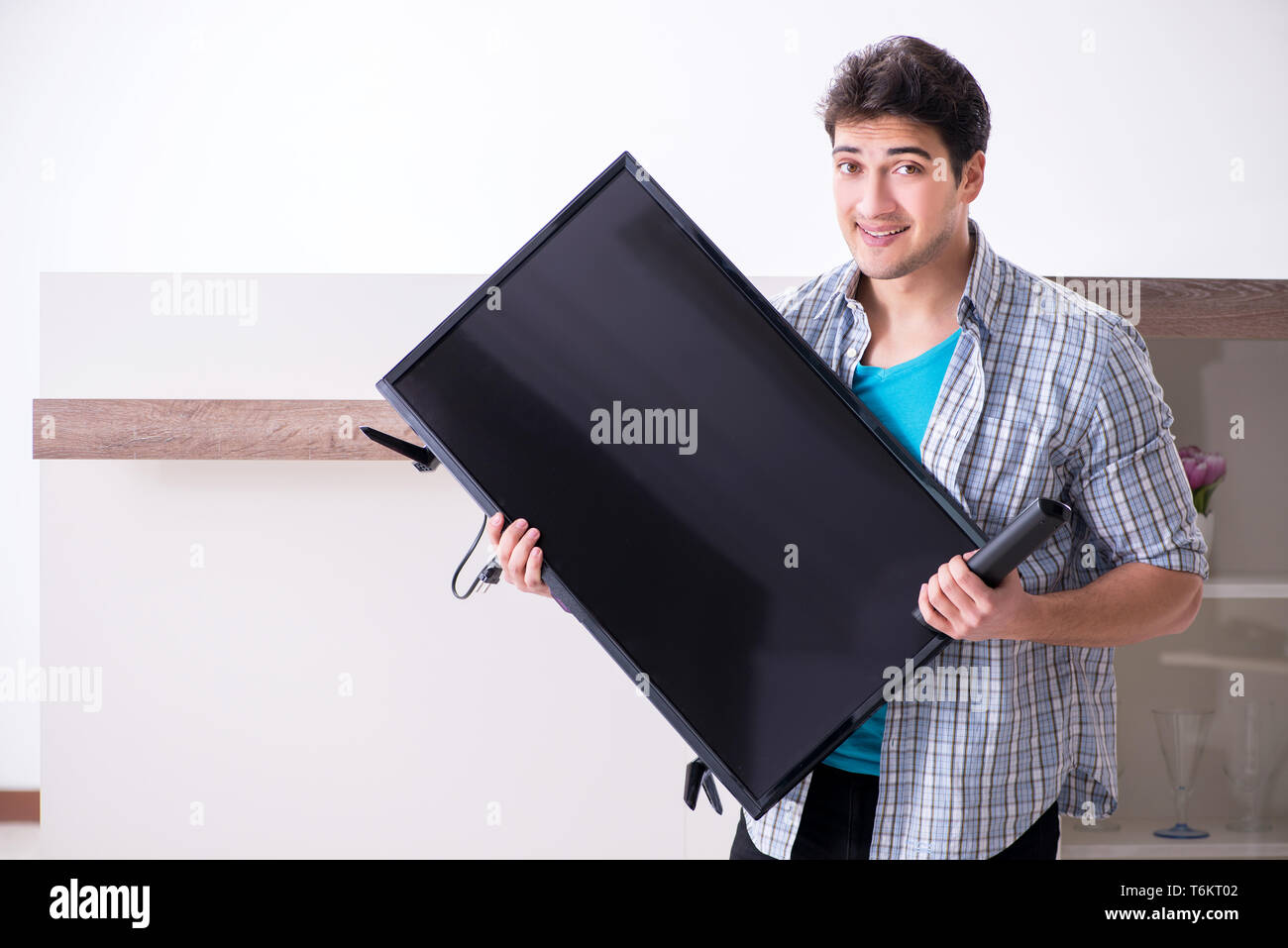 Man trying to fix broken tv Stock Photo - Alamy