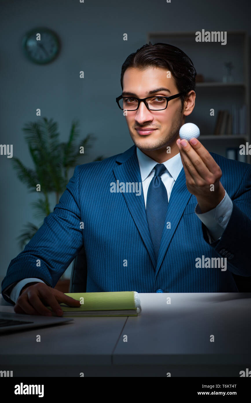 Young employee with golf ball in office Stock Photo - Alamy