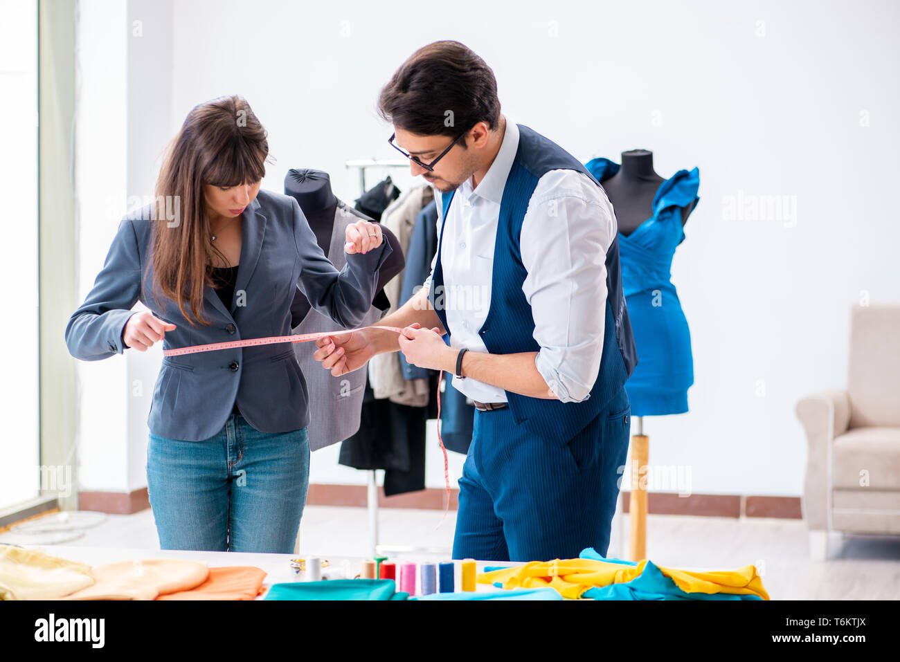 Professional tailor taking measurements for formal suit Stock Photo - Alamy