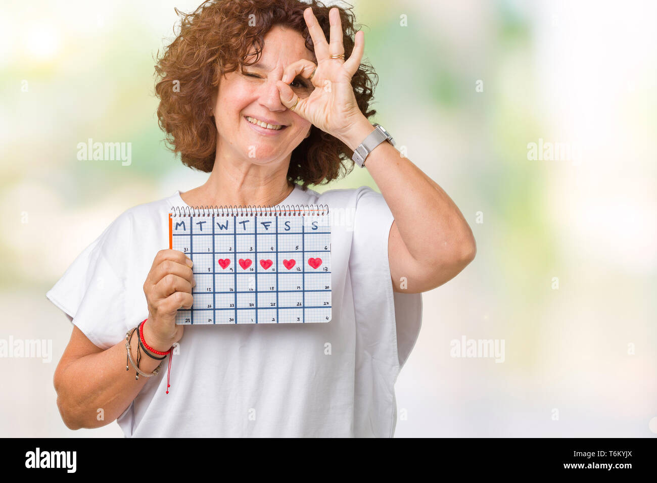 Middle ager senior woman holding menstruation calendar over isolated ...
