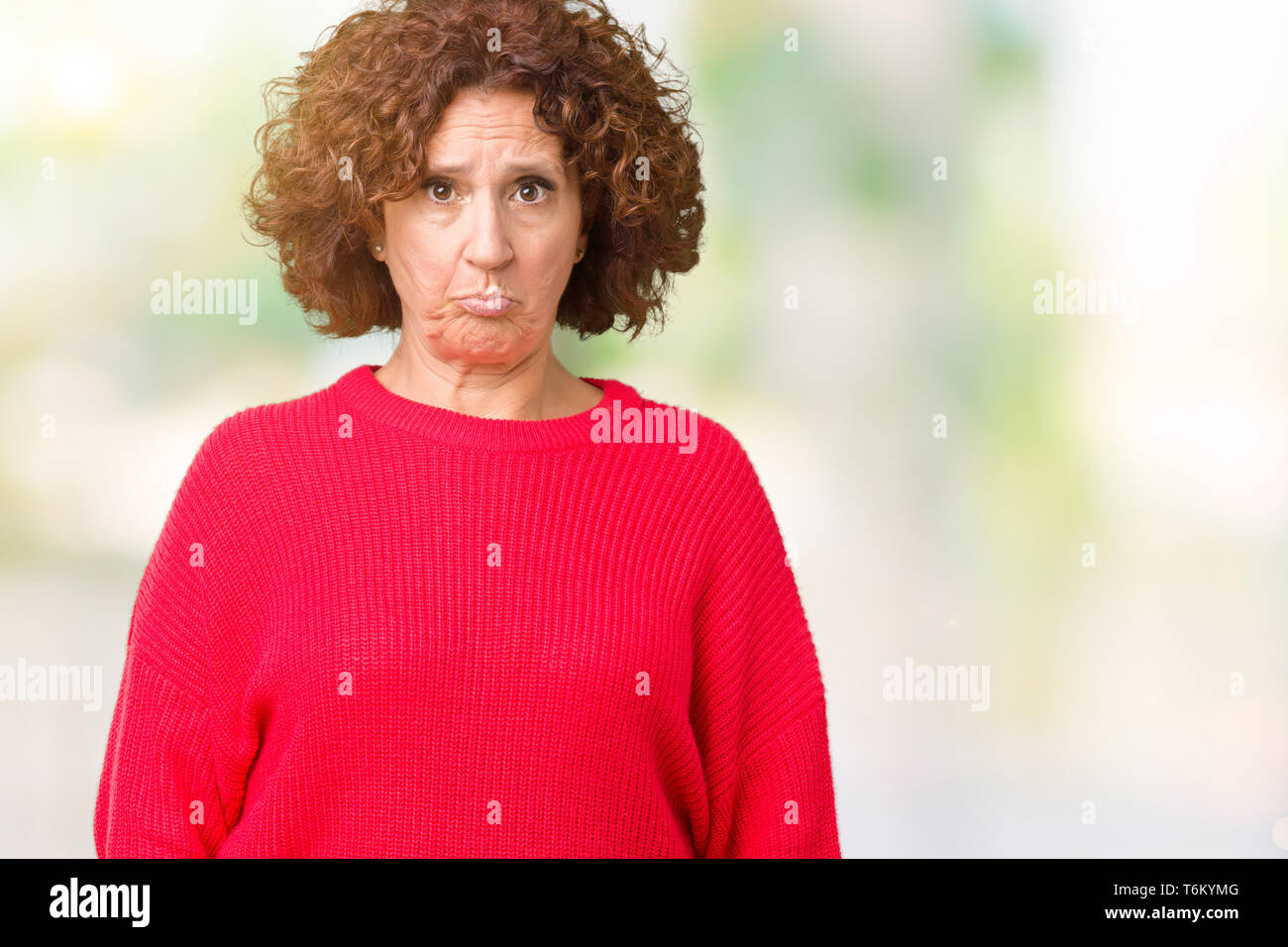 Beautiful middle ager senior woman red winter sweater over isolated ...