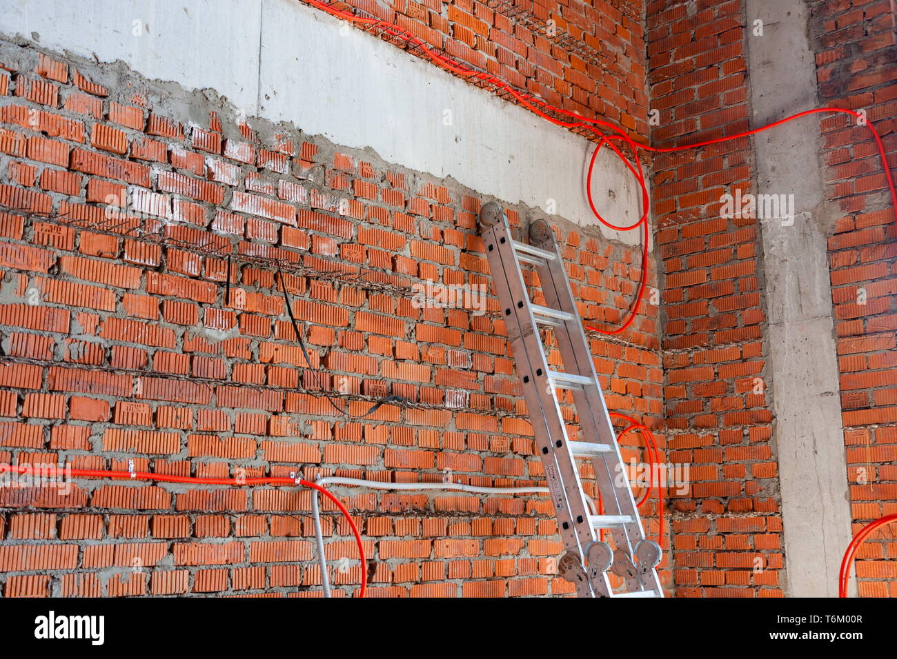 Fast ladder at the brick wall and wires. Red bricks Stock Photo - Alamy