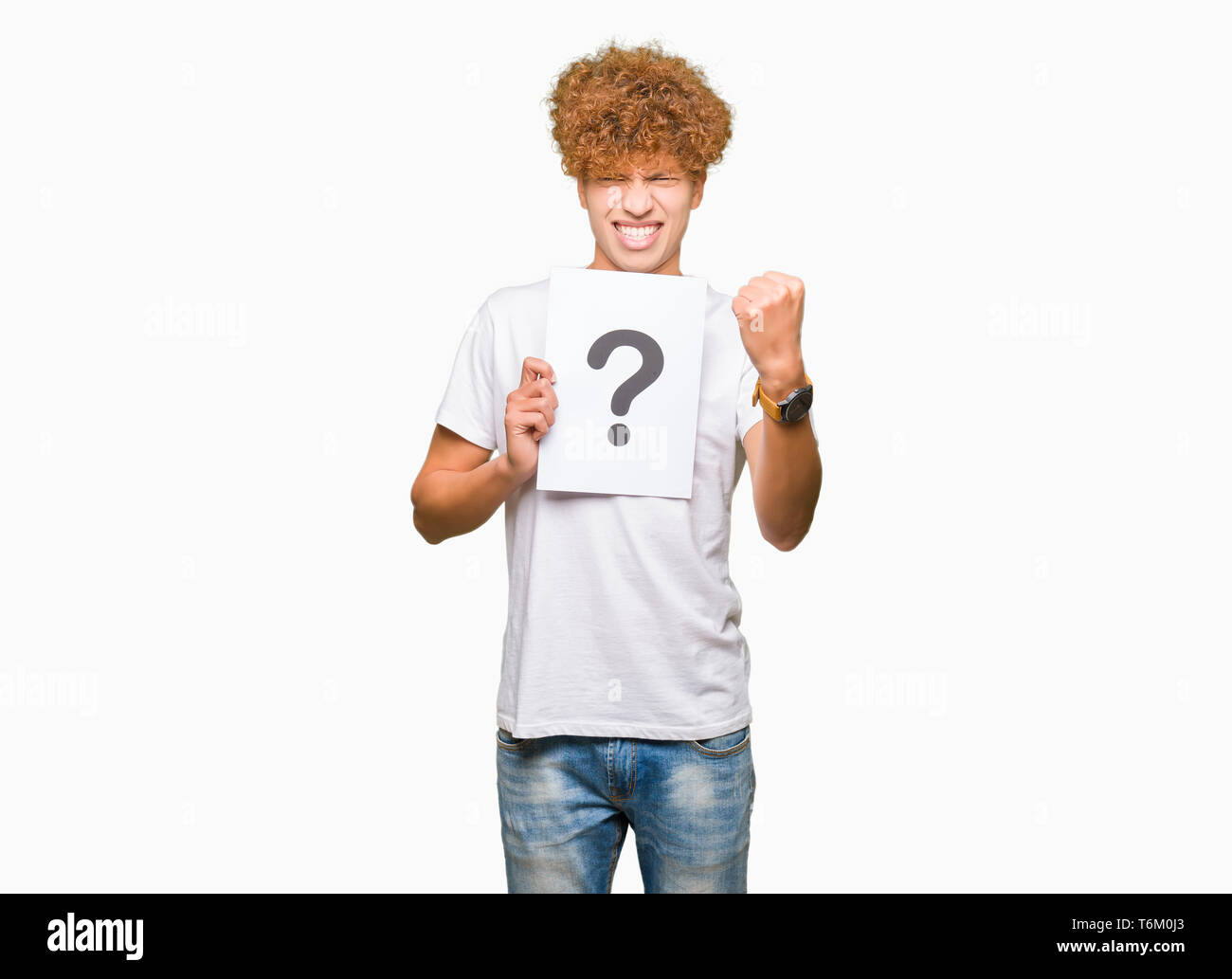 Young handsome man holding paper with question mark screaming proud and ...