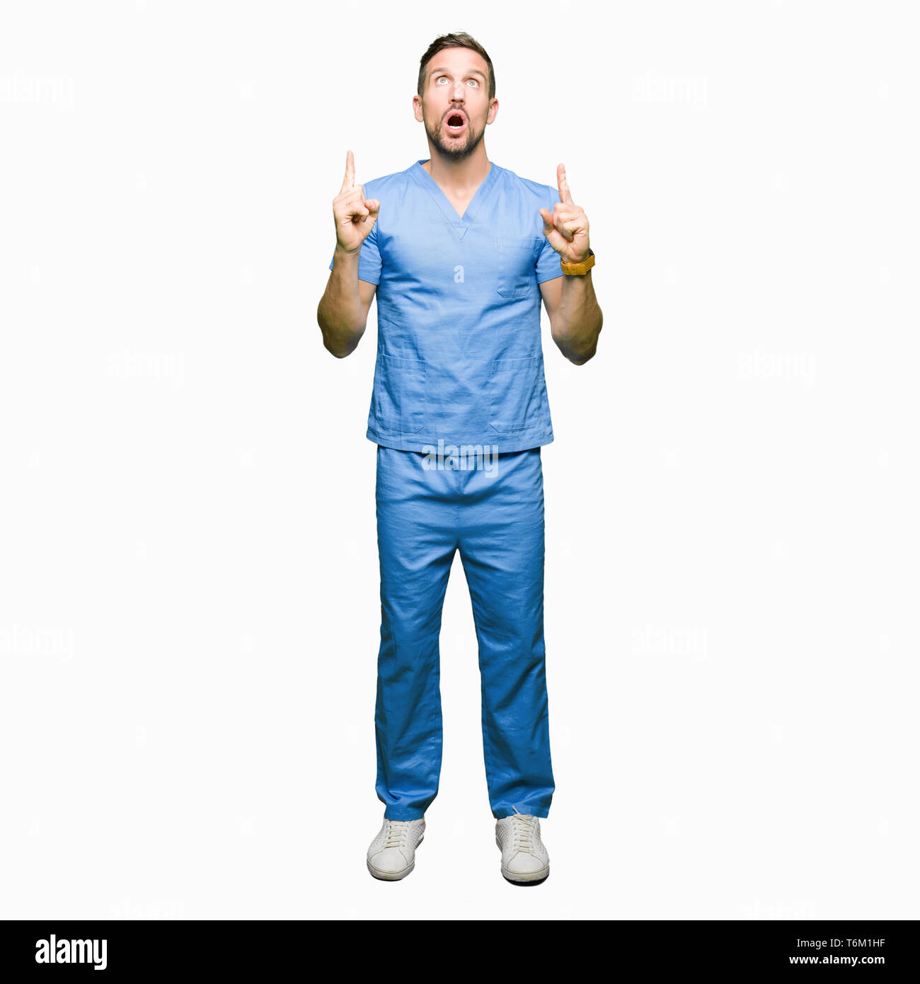 Handsome doctor man wearing medical uniform over isolated background ...