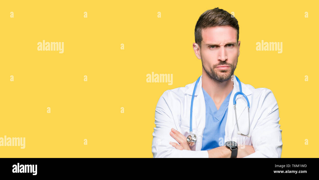 Handsome doctor man wearing medical uniform over isolated background ...